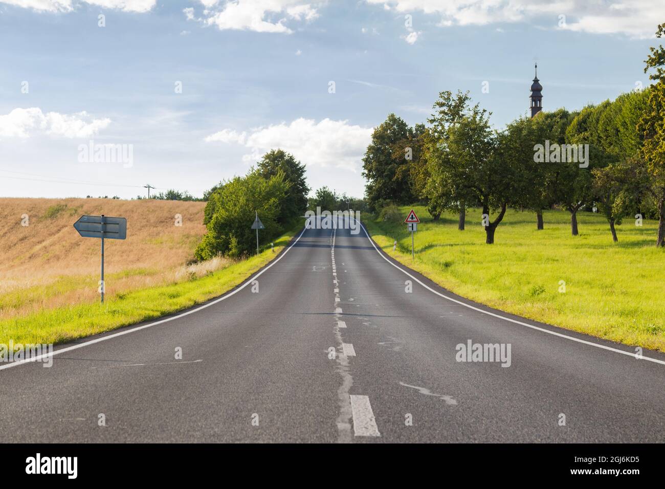 view in the middle of an asphalt road disappearing into the distance ...