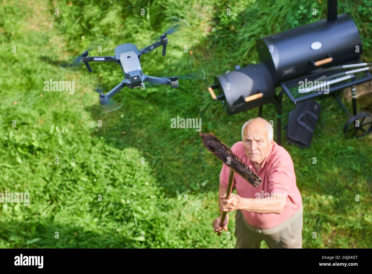 Název: Old senior man upset by a flying drone over his garden. The ...