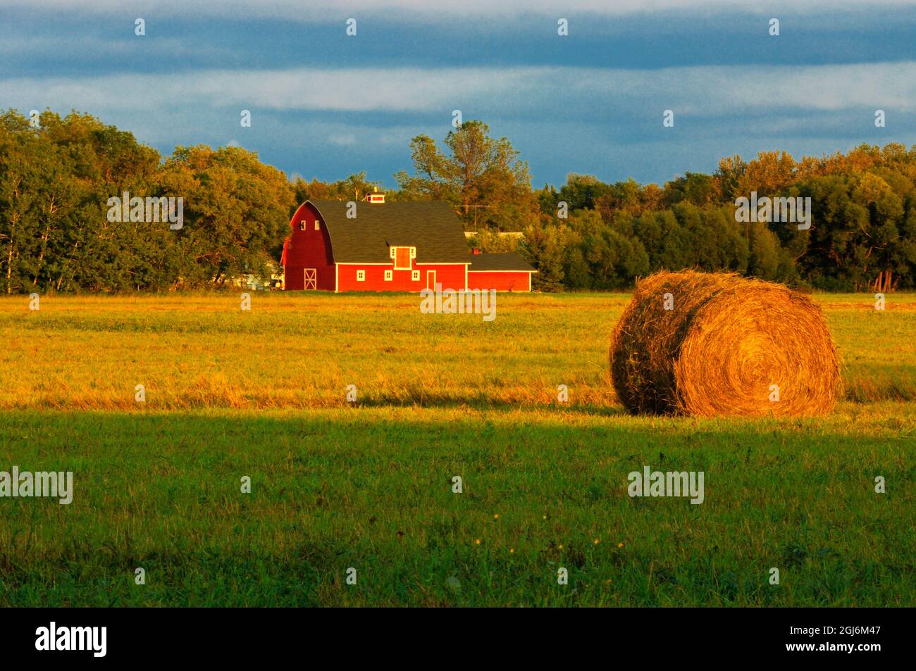 Canada, Manitoba, Matlock. Red barn and bale at sunrise. Credit as ...
