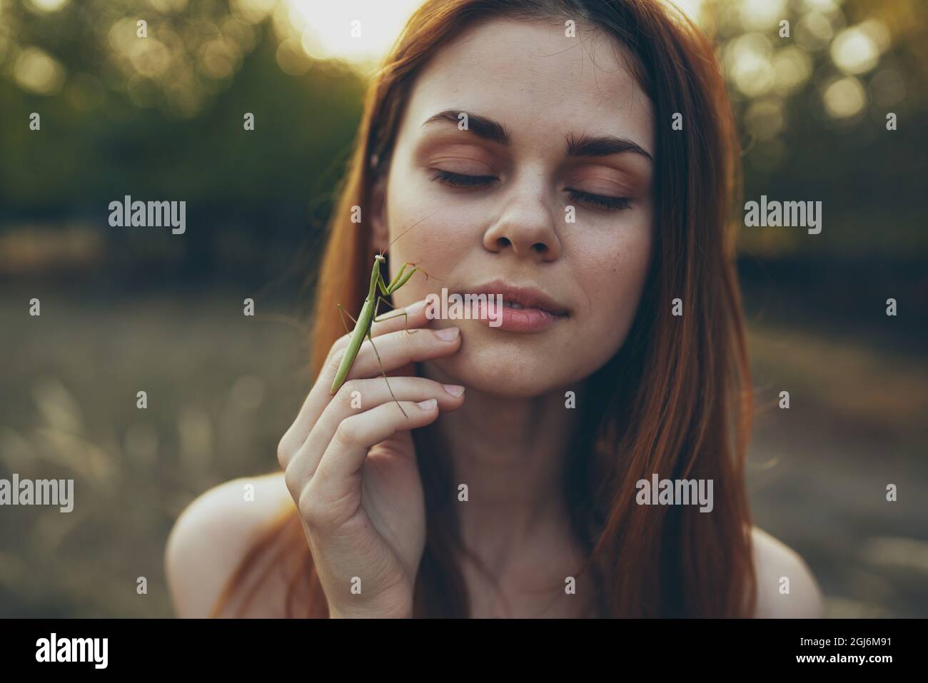 red-haired woman with a praying mantis in hand nature stroll Stock ...