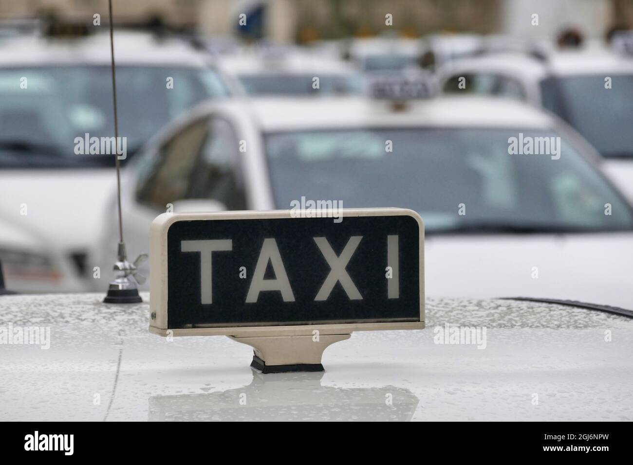 Closeup of the taxi cab roof sign. Cars parked in rows waiting for ...