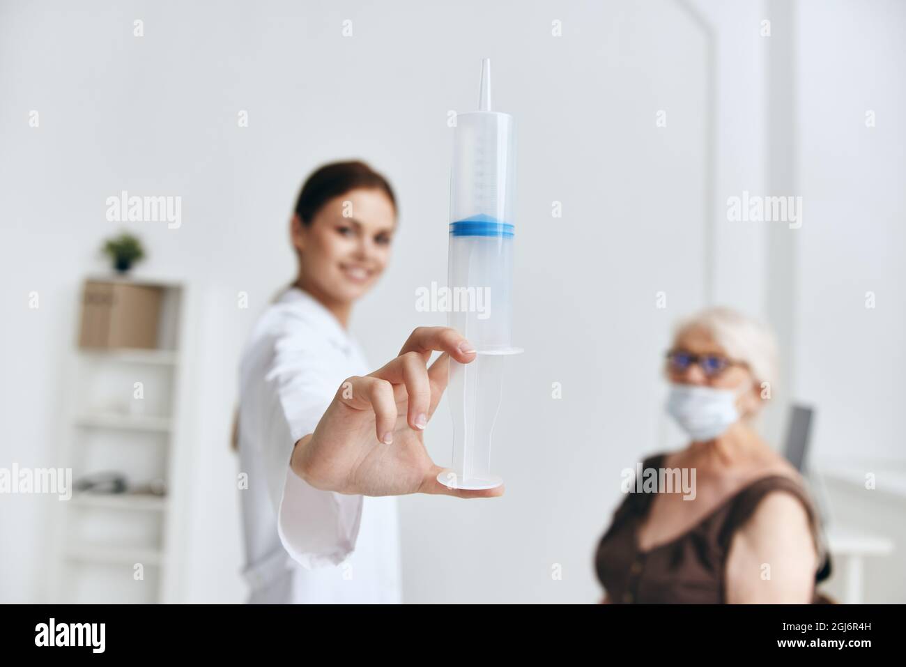 Nurse giving an injection to an elderly woman vaccination immunity ...