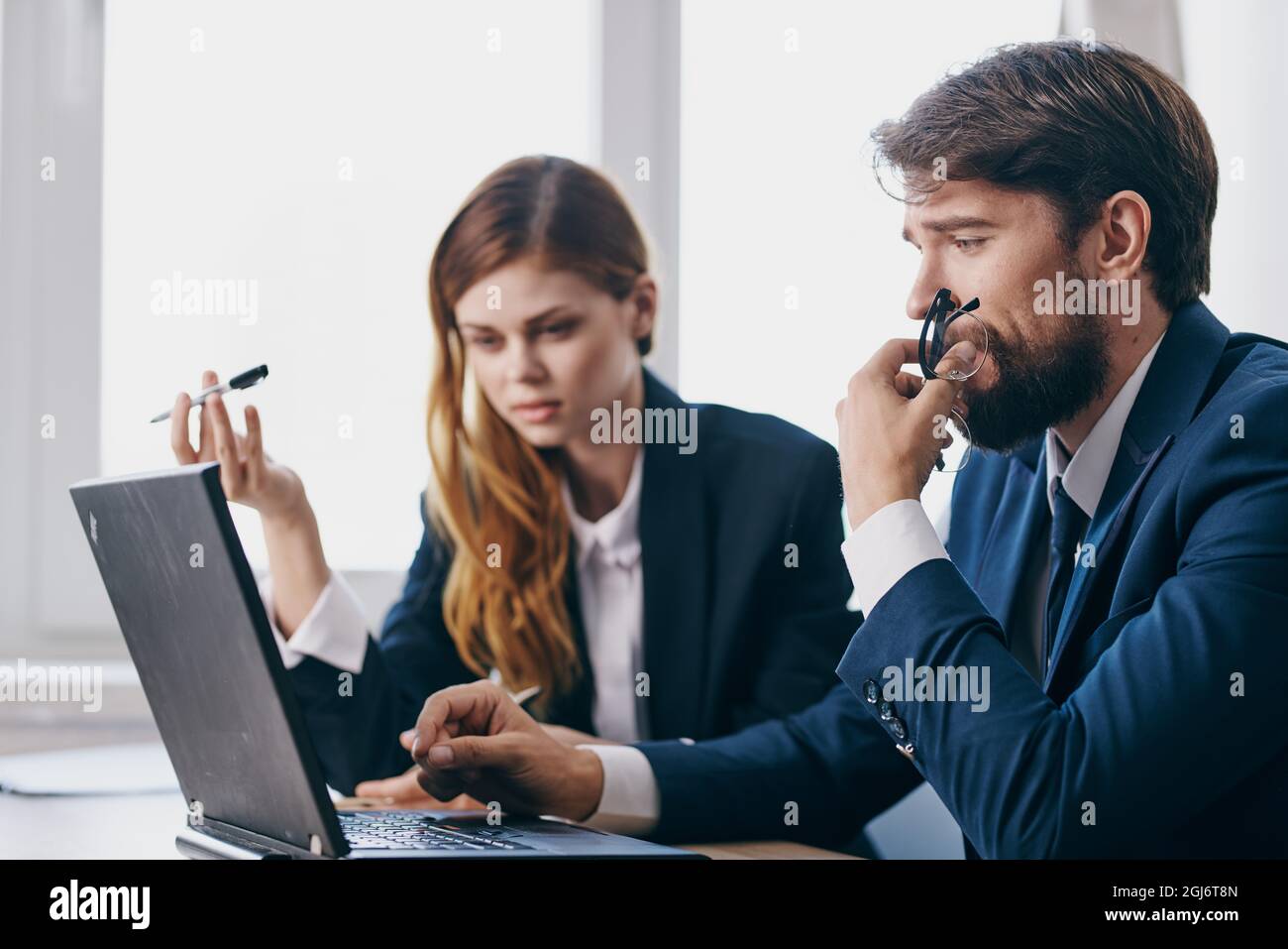 business man and woman sitting in front of a laptop teamwork ...