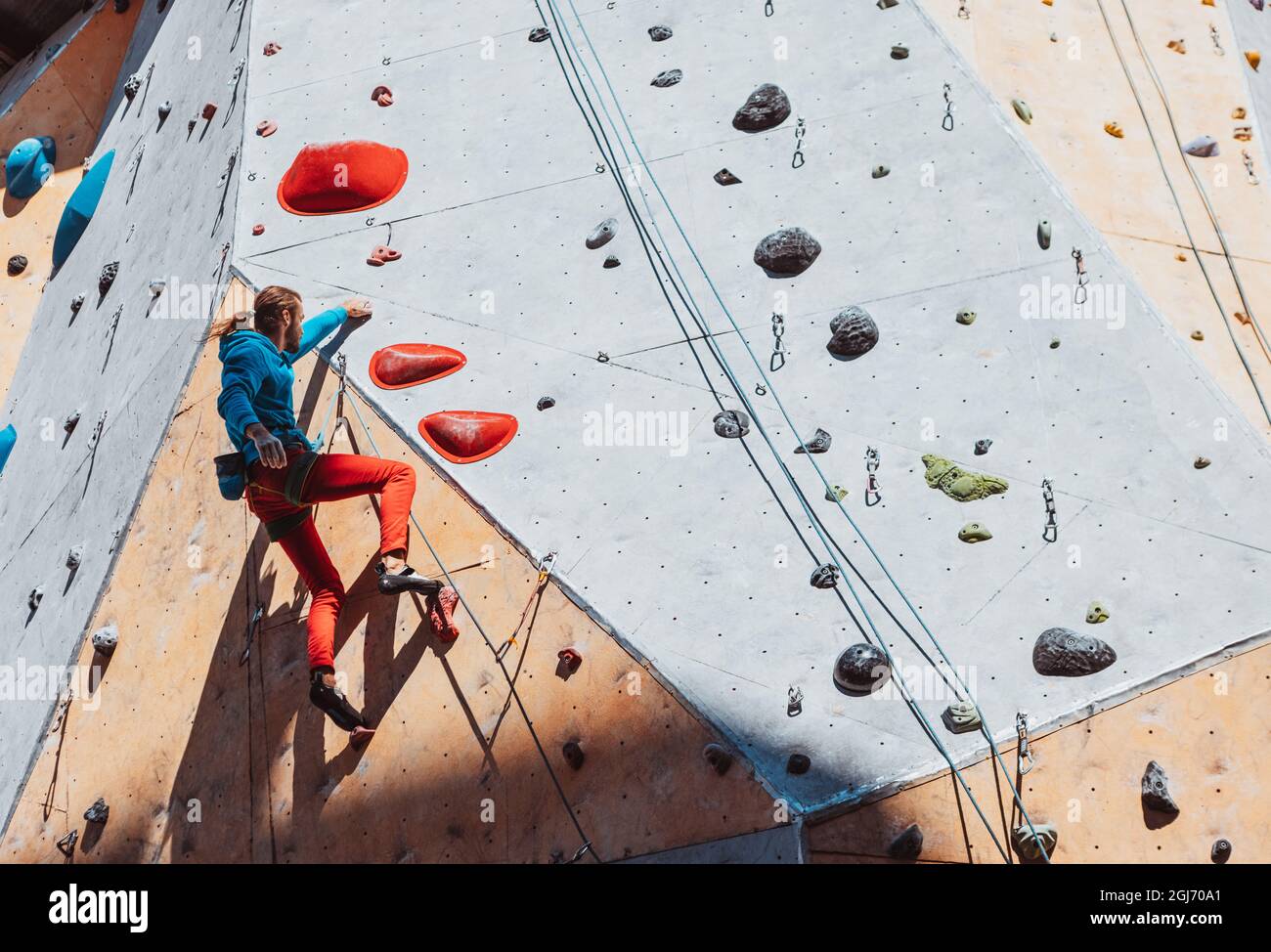 Hard level. Young man professional rock climber practicing at training ...
