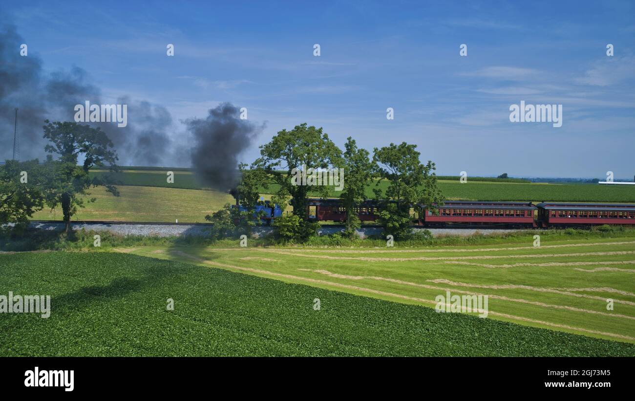 Thomas the tank engine pulling passenger cars and blowing smoke on a ...