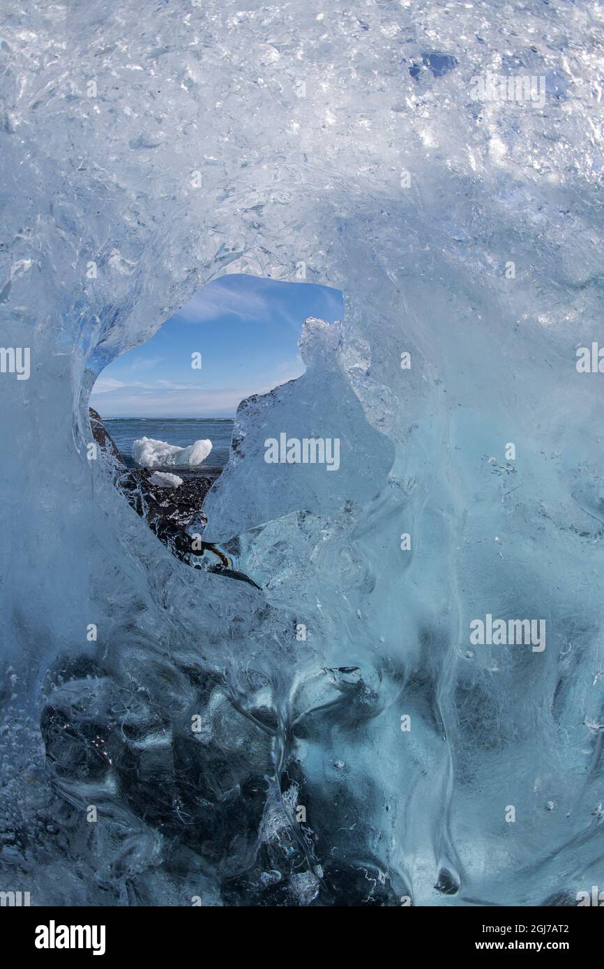 A hole in a huge piece of ice serves as a window to diamond beach ...