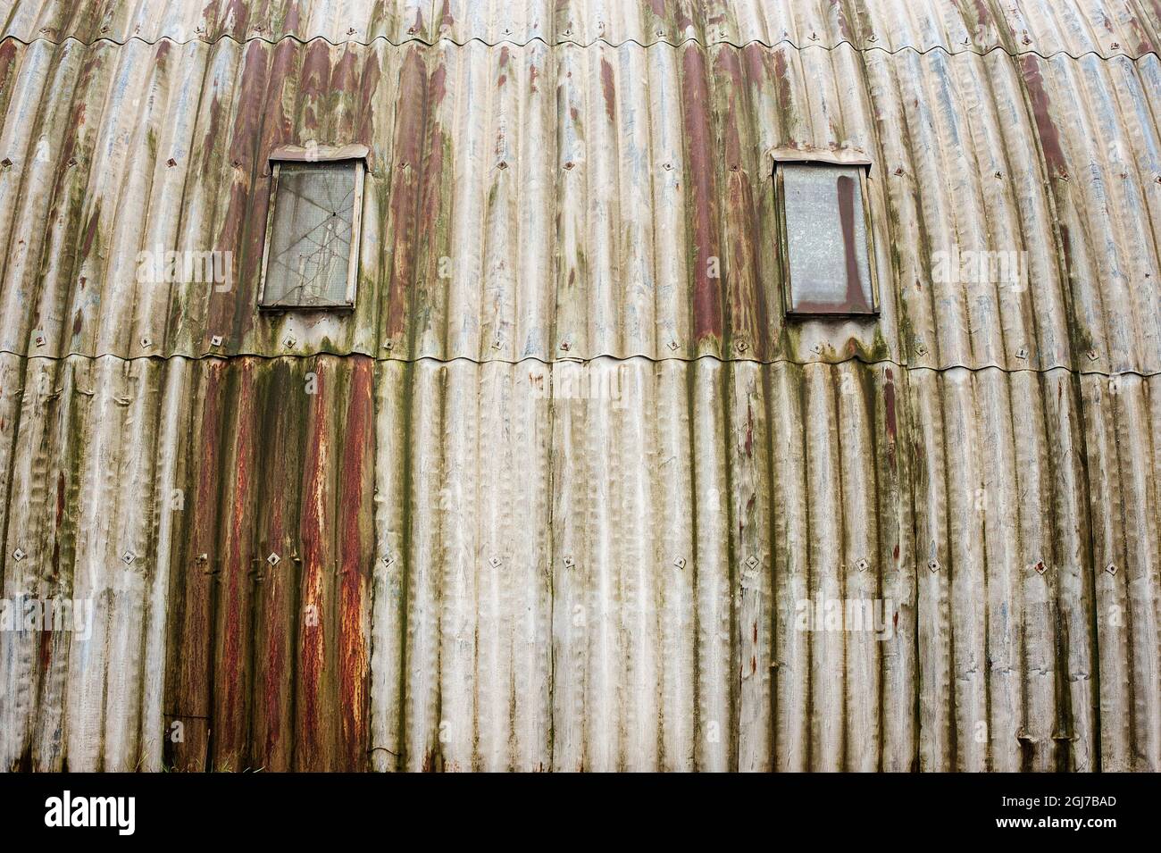 Rusty metal wall surface, old abandoned warehouse with broken windows ...