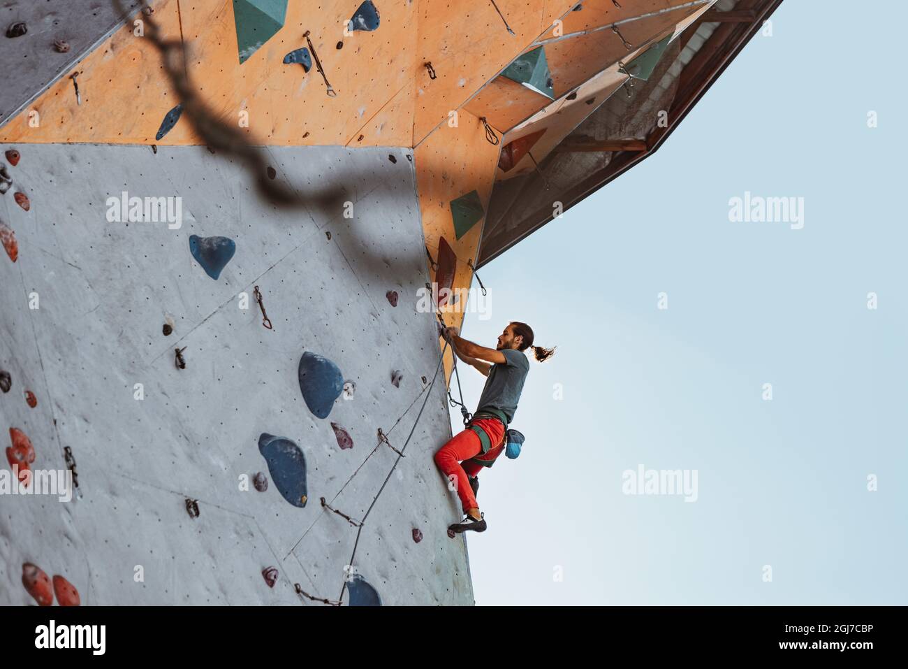 Young man professional rock climber practicing at training center in ...