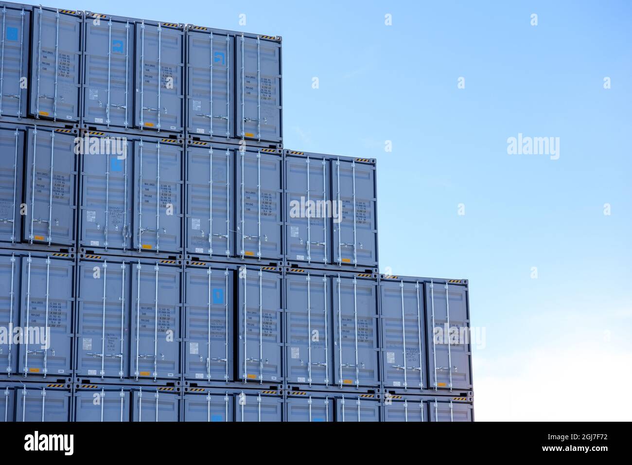 Behind a pile of containers in the deposit yard Stock Photo - Alamy