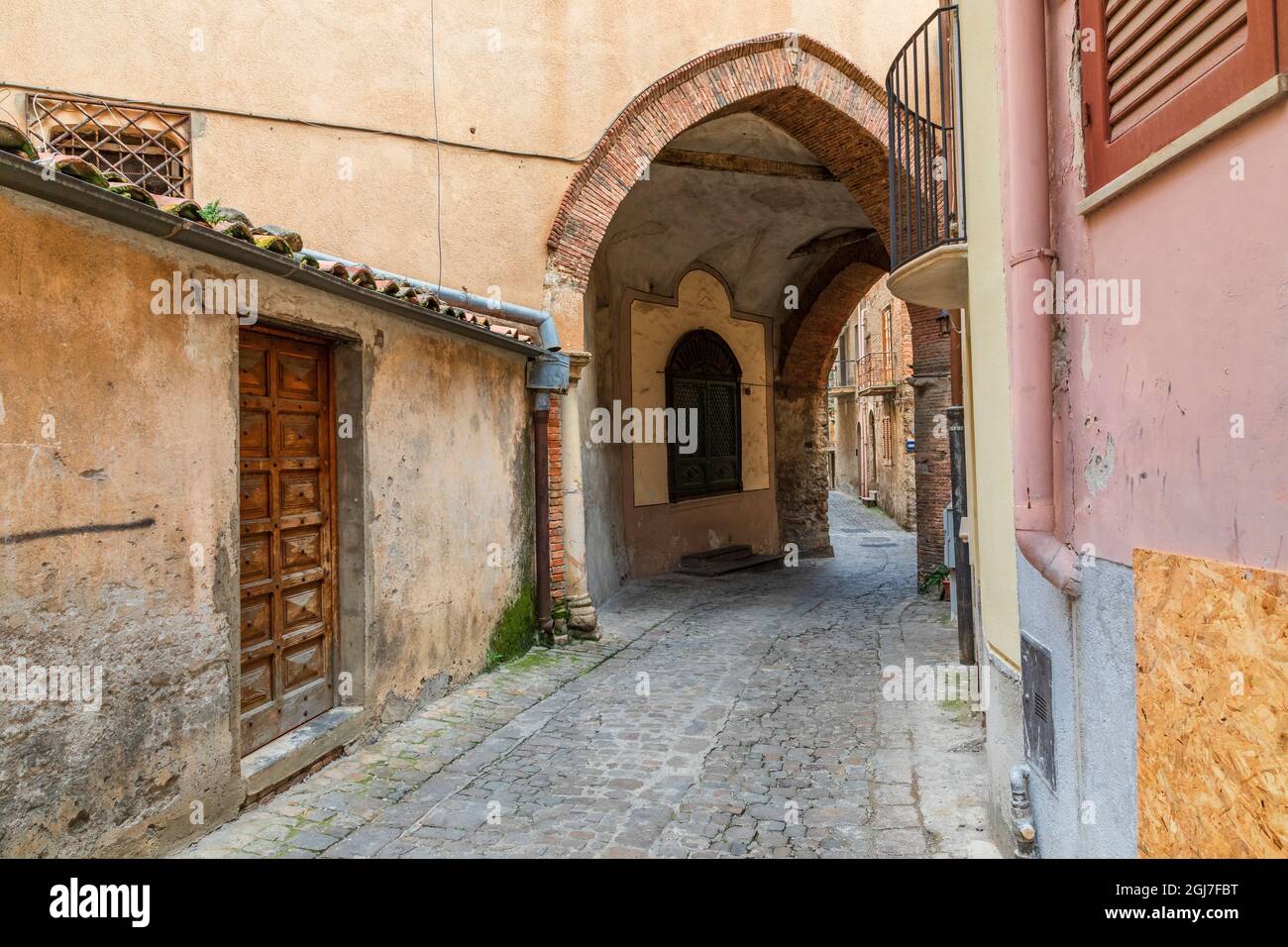 Italy, Sicily, Palermo Province, Castelbuono. Archway over cobblestone ...