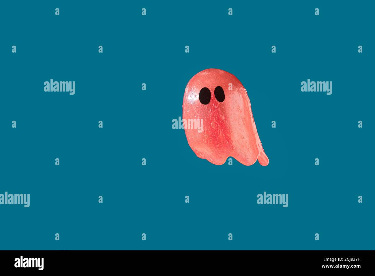 Pink slime ghost with black eyes against cyan background Stock Photo ...