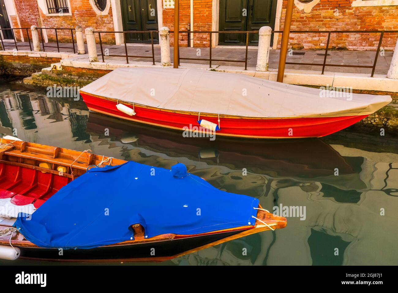 Colorful small boats and side canal with reflection in Venice, Italy ...
