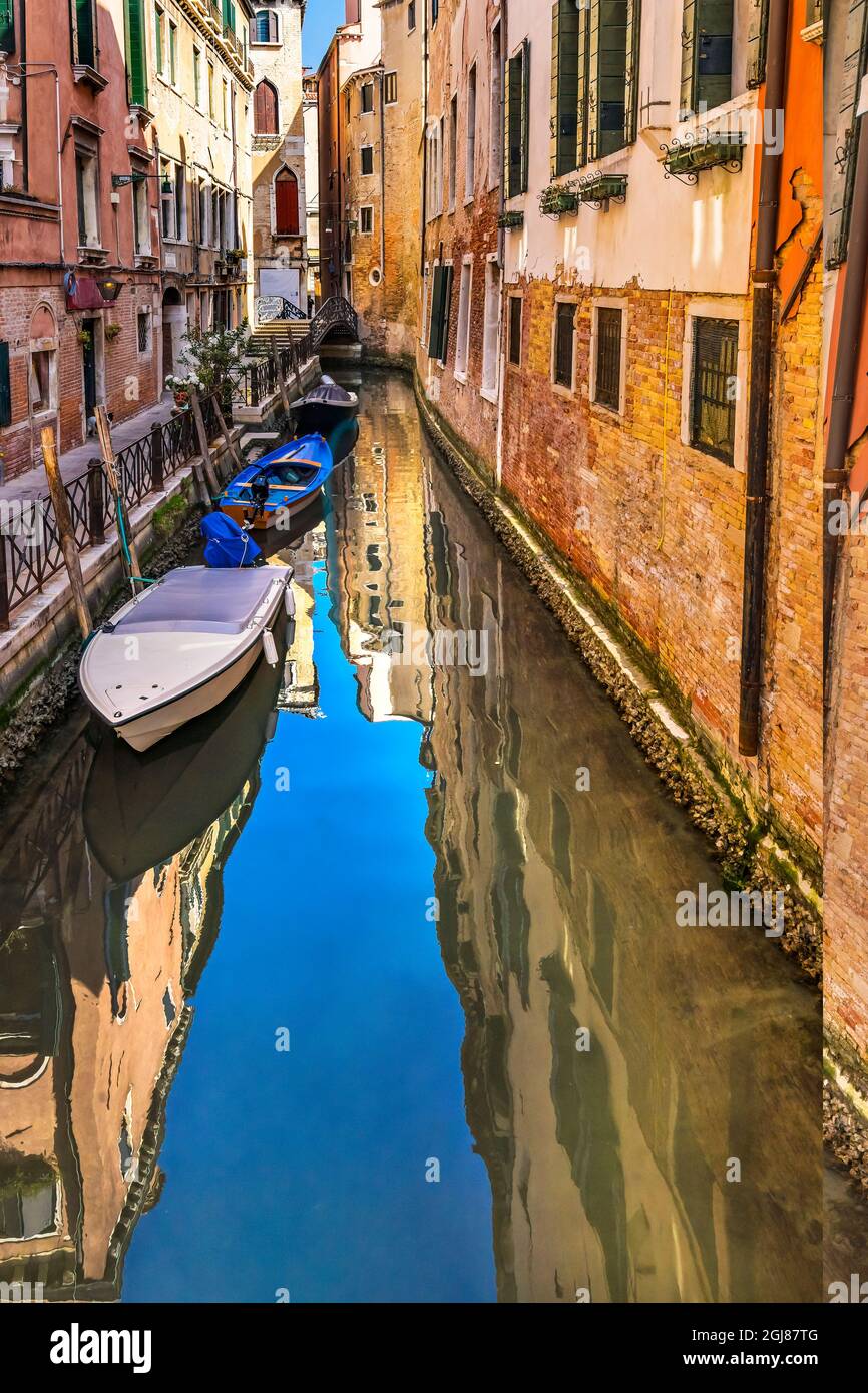 Colorful small canal and bridge creating beautiful reflection in Venice ...