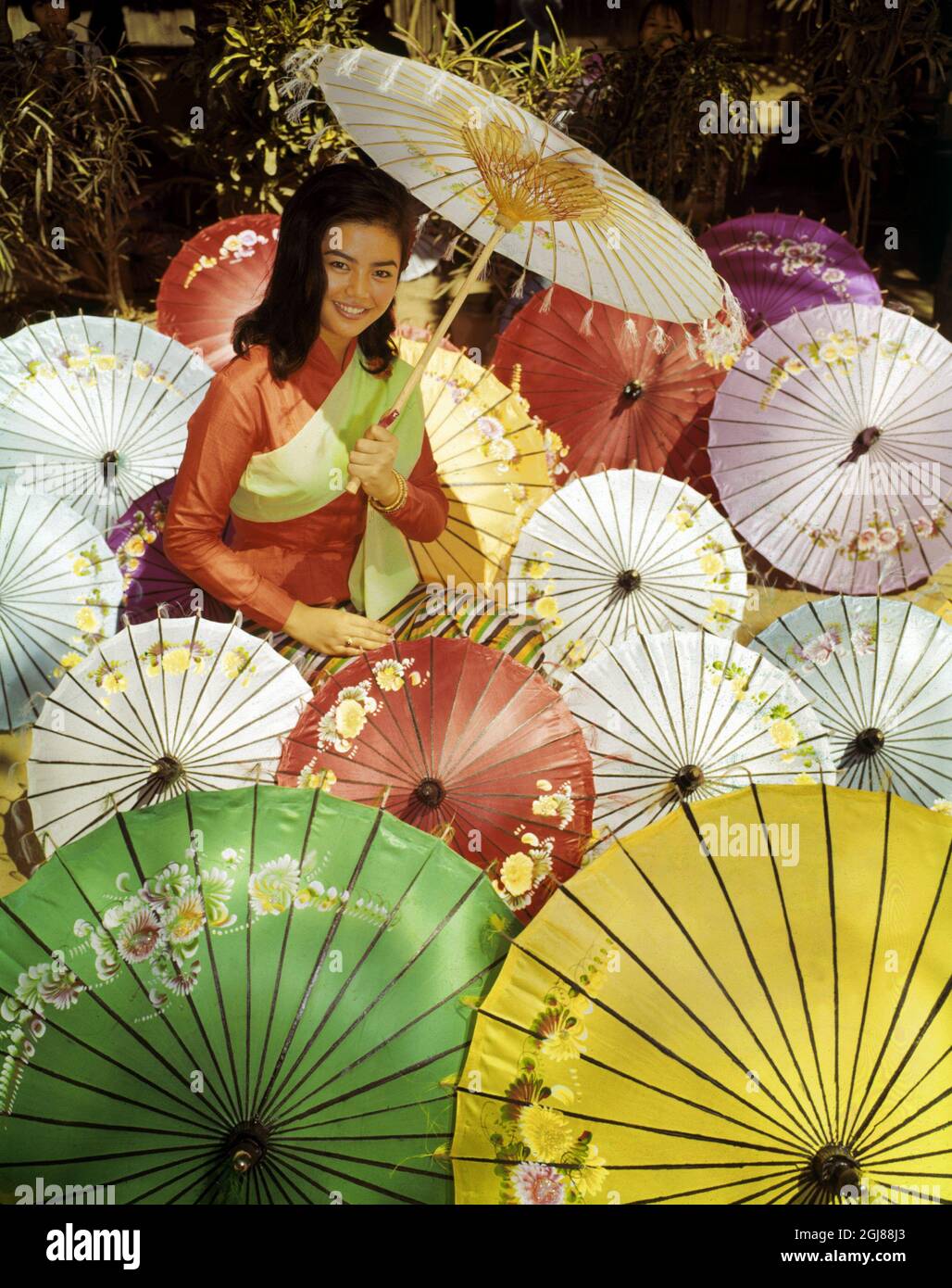 THAILAND Photo Date: 1960 -? -? FILE A girl demonstrates sun umbrellas ...