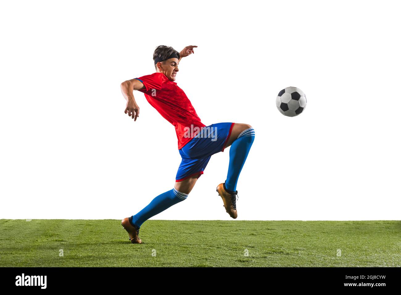 Full-length portrait in motion of male soccer football player kicking ...