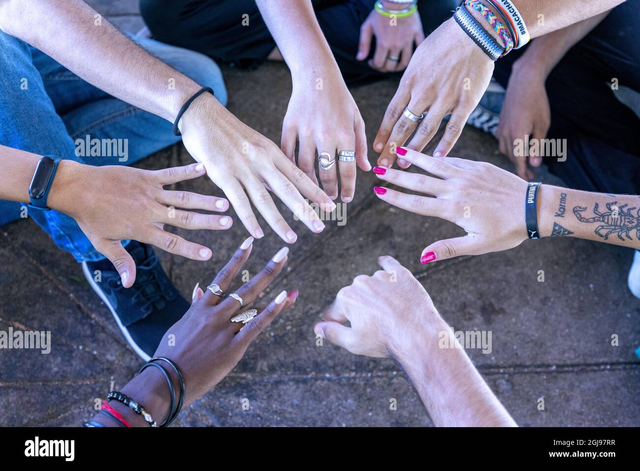 Op view of young people folding their hands together Stock Photo - Alamy