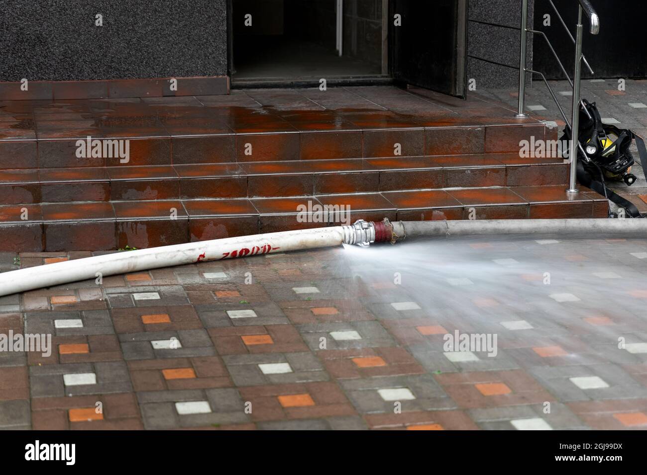 Close-up old worn out broken fire hose leaking with high pressure water ...