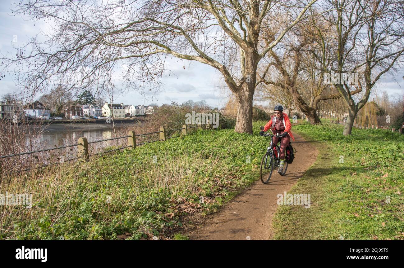 Woman cycling the south side Thames Path in London, U.K Stock Photo - Alamy