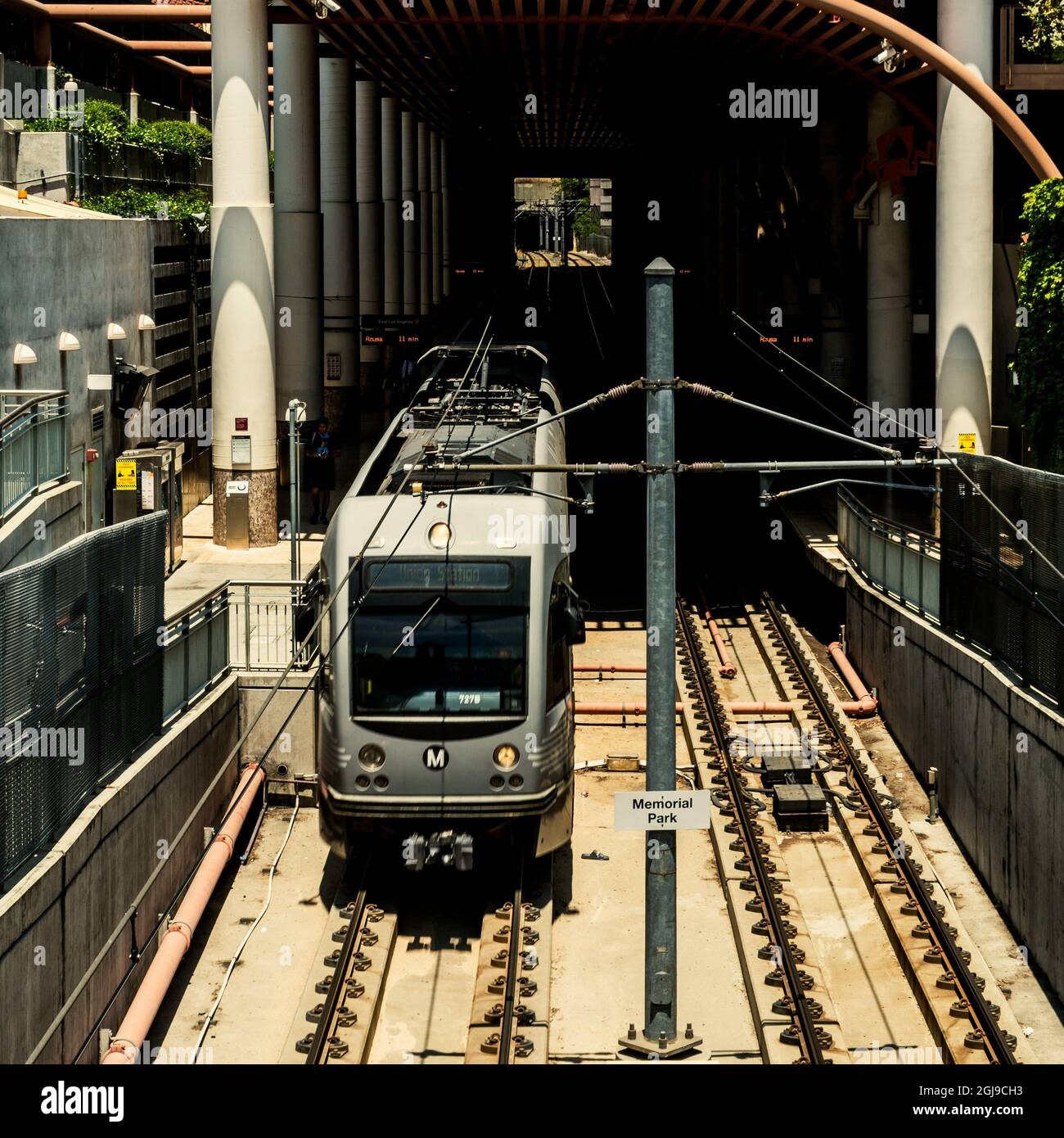 Gray train on the left side of the railway departing from the station ...