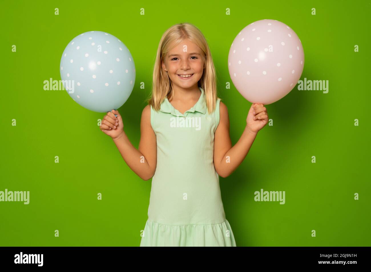 Adorable little kid with balloons isolated over green background Stock ...