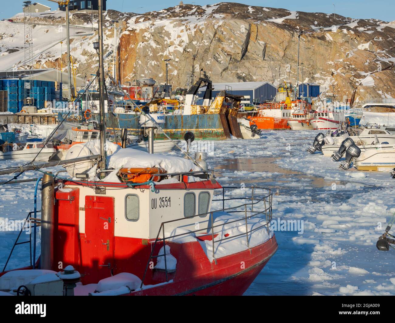 Winter in the frozen harbor of town Ilulissat on the shore of Disko Bay ...