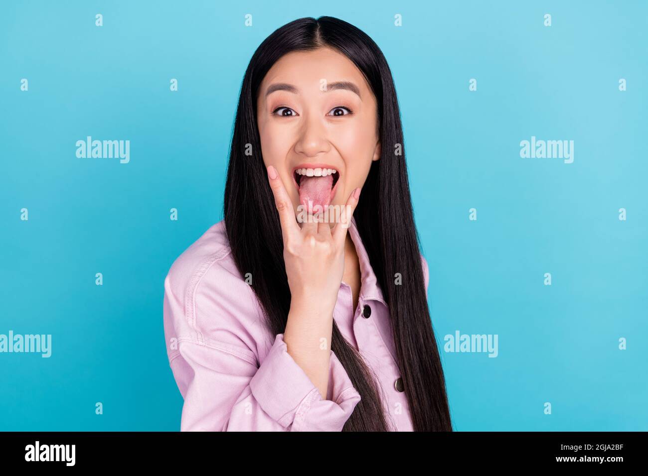 Portrait of attractive cheerful crazy childish girl showing horn sign ...