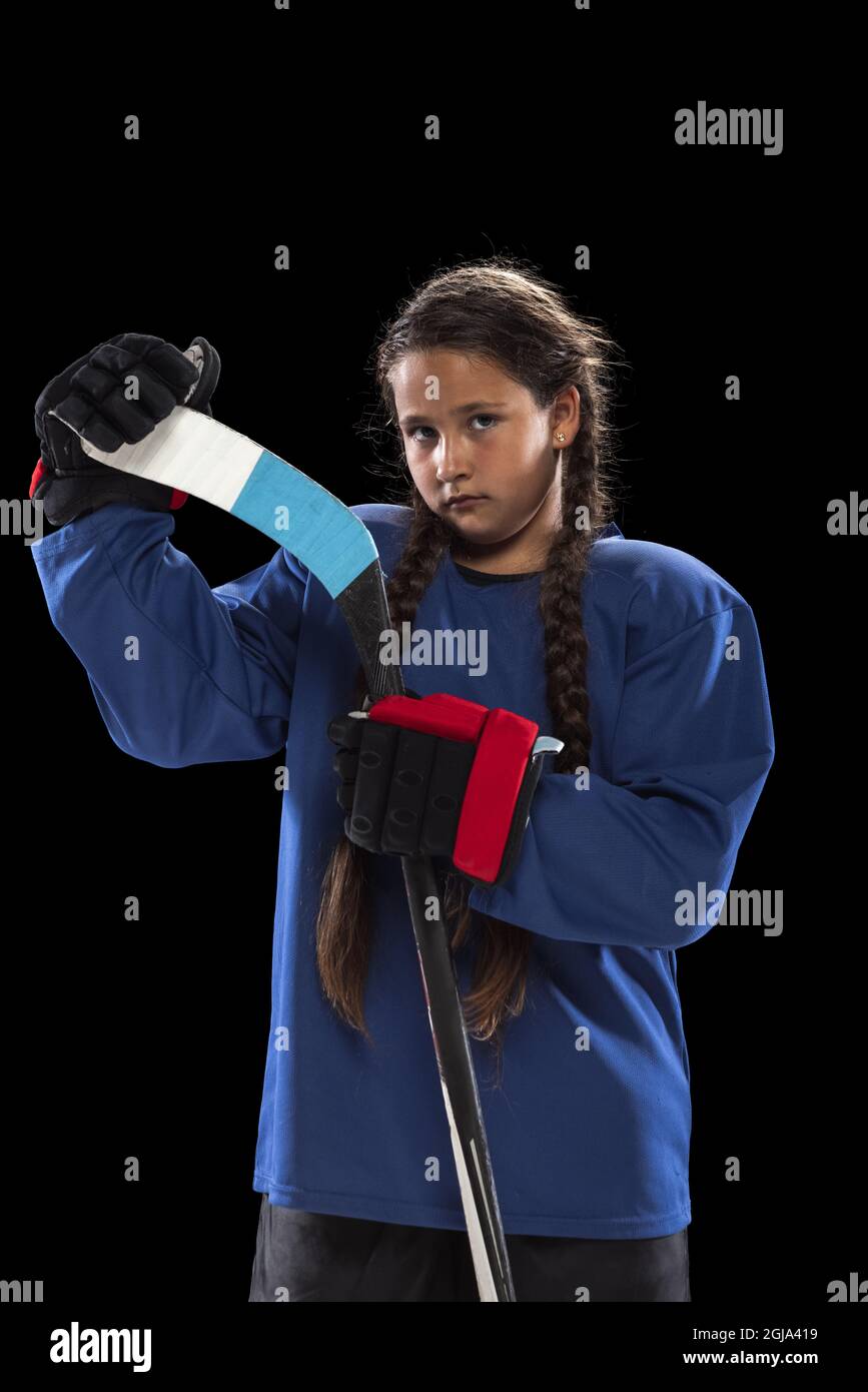 Cropped portrait of young girl hockey player in uniform, helmet and ...