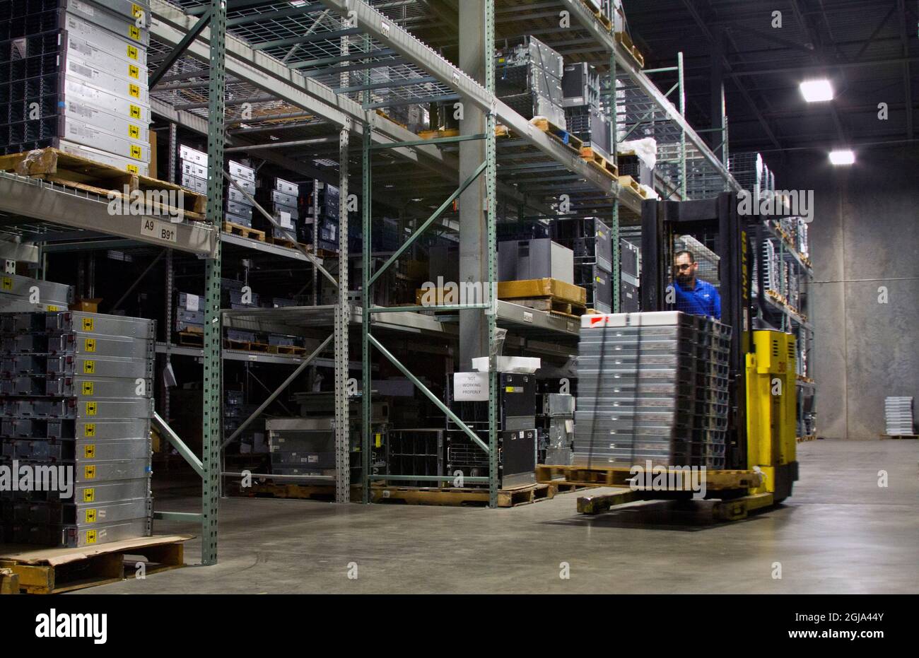 Employee working on forklift inside computer technology warehouse Stock ...