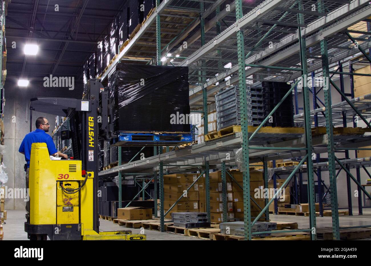 Employee working on forklift inside computer technology warehouse Stock ...