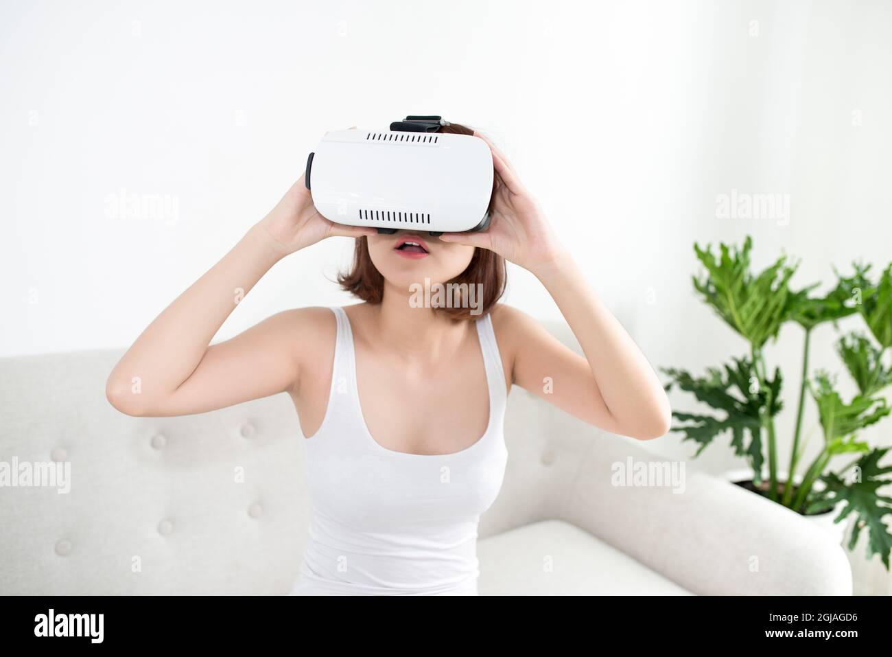 Attractive young woman adjusting her VR headset and smiling Stock Photo ...