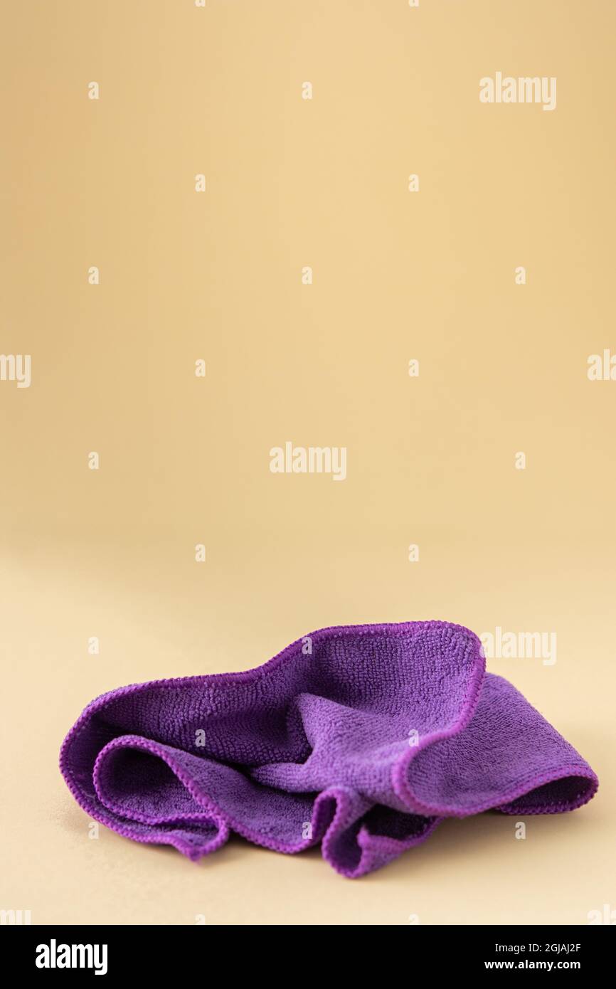 Purple microfiber cloth for washing on a neutral beige background ...