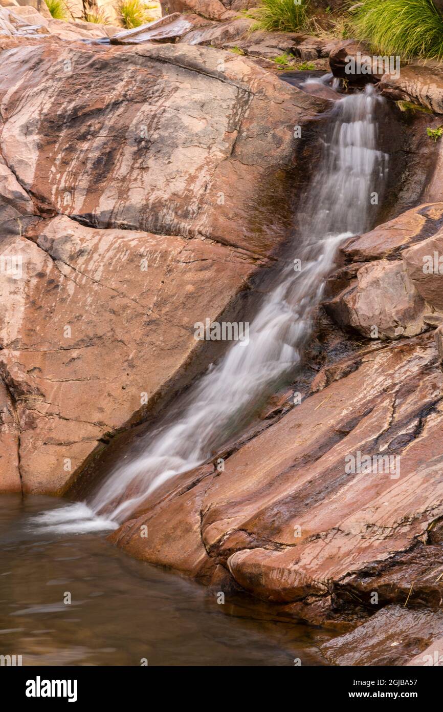 USA, Arizona, Superstition Wilderness. Water cascade down rock face ...