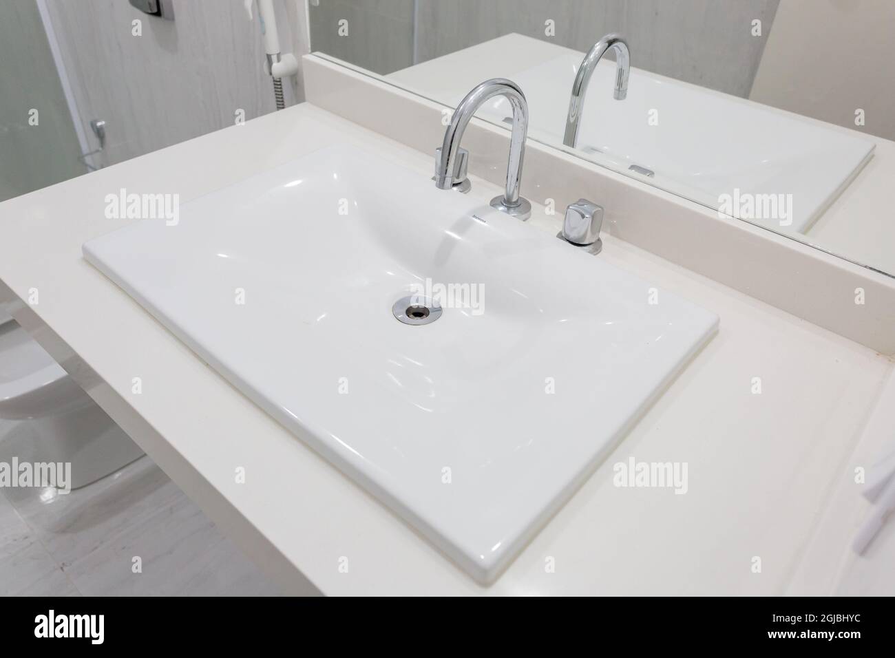 Water tap reflecting in the mirror behind it Stock Photo - Alamy