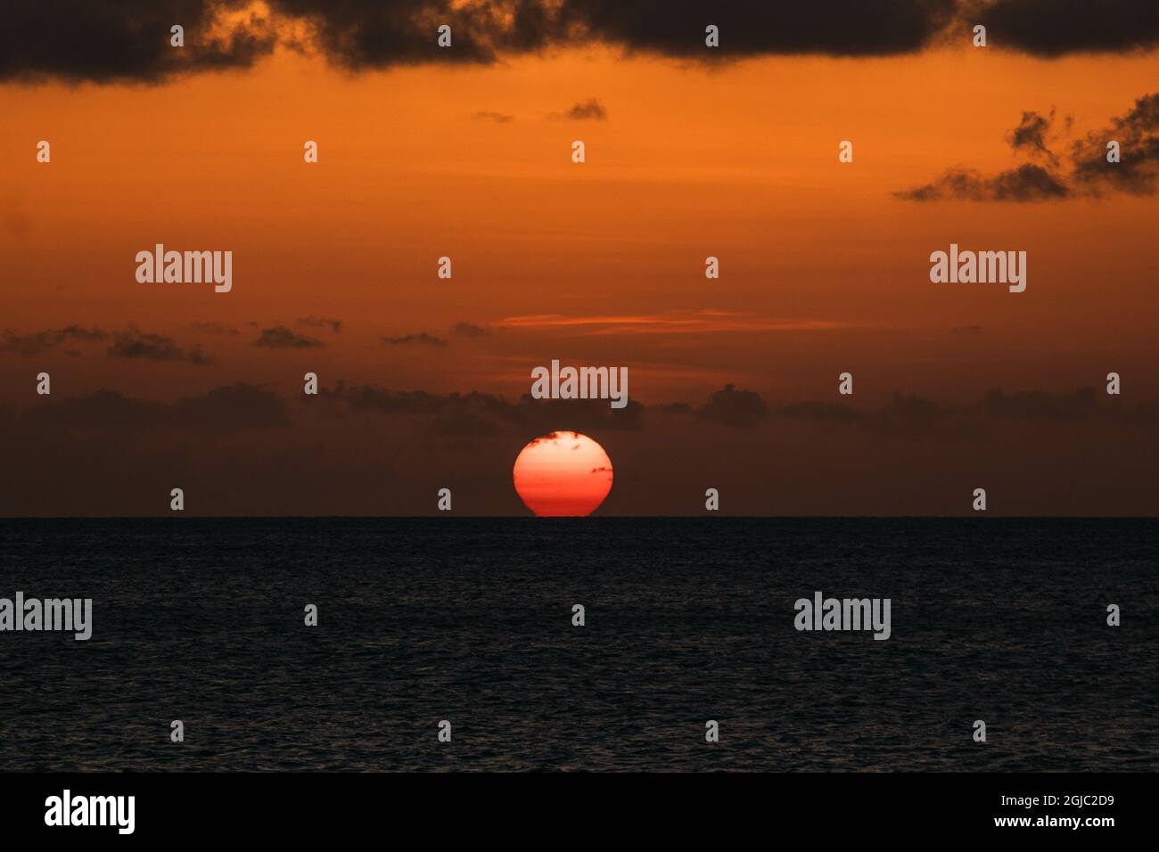 Glorious scenery of a golden sunset by the ocean with orange ombre sky ...