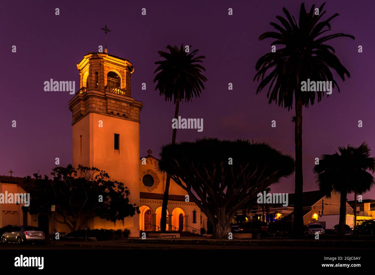 Church lit up at night against a purple sky, just after sunset, with ...