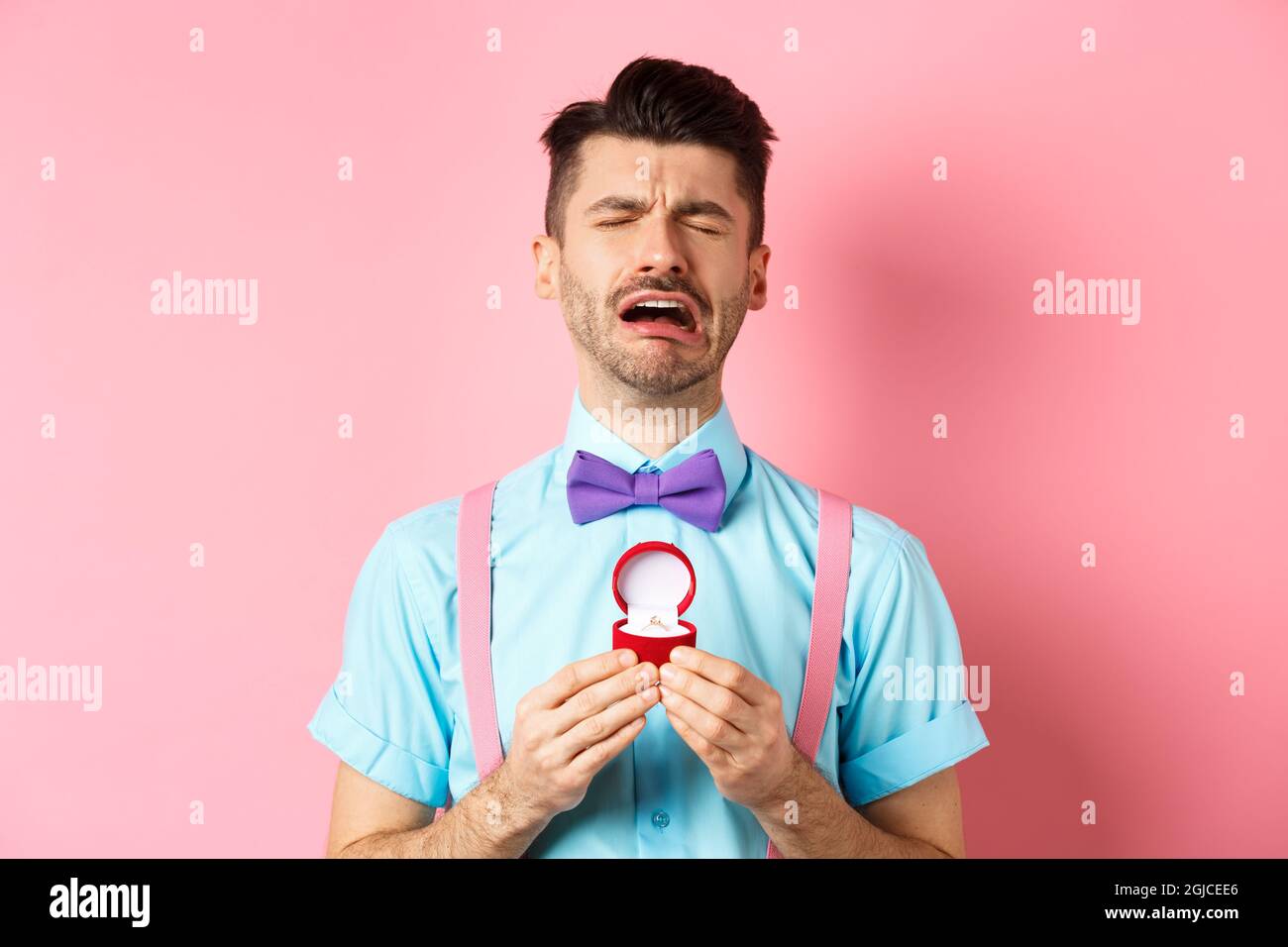 Valentines day. Heartbroken guy crying and holding engagement ring ...