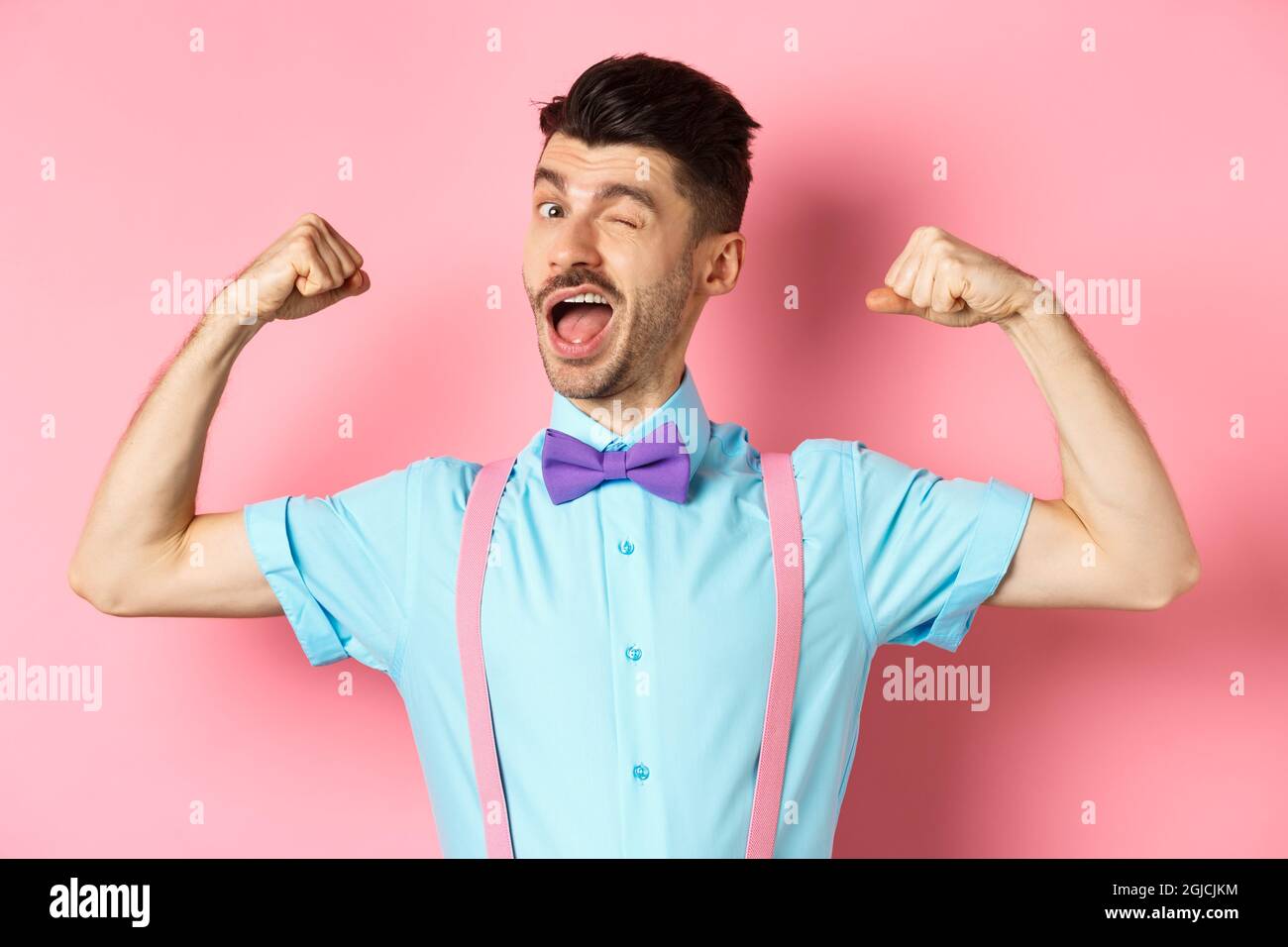 Strong and funny guy with french moustache, flexing biceps and winking ...