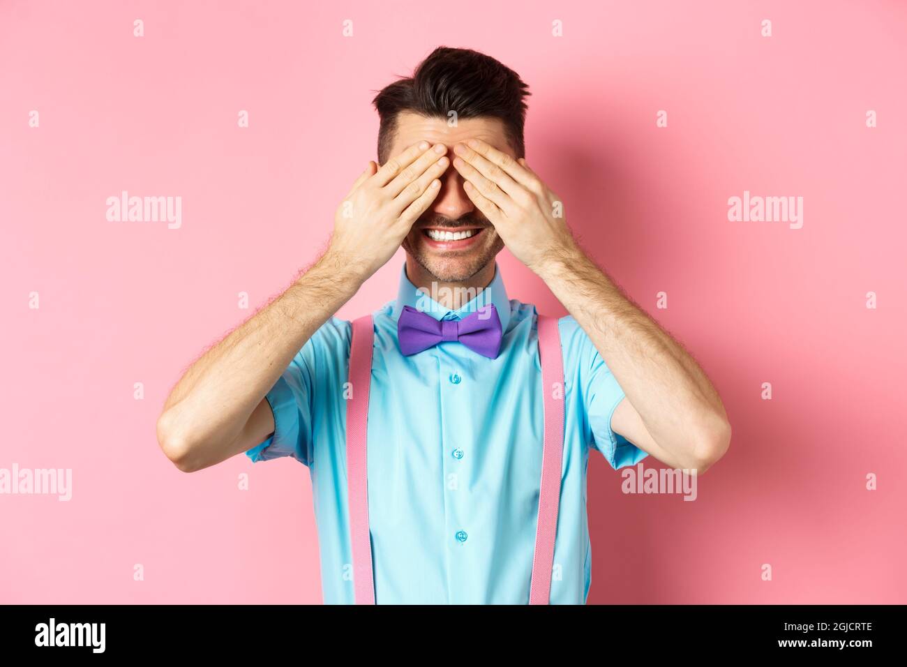 Image of smiling handsome guy waiting for surprise with closed eyes ...