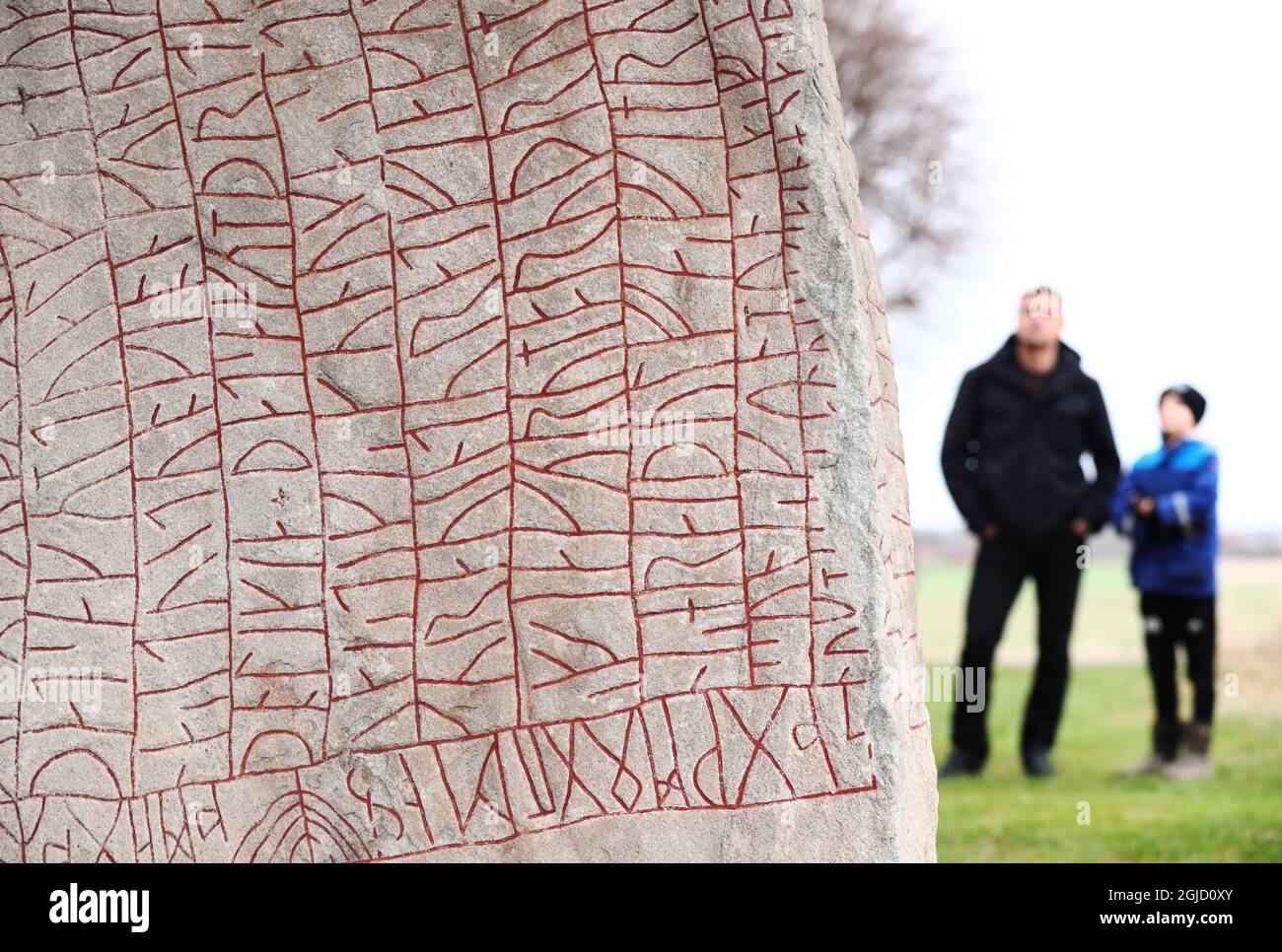 A father and a son look at the Viking-era Rok runestone near the Lake ...