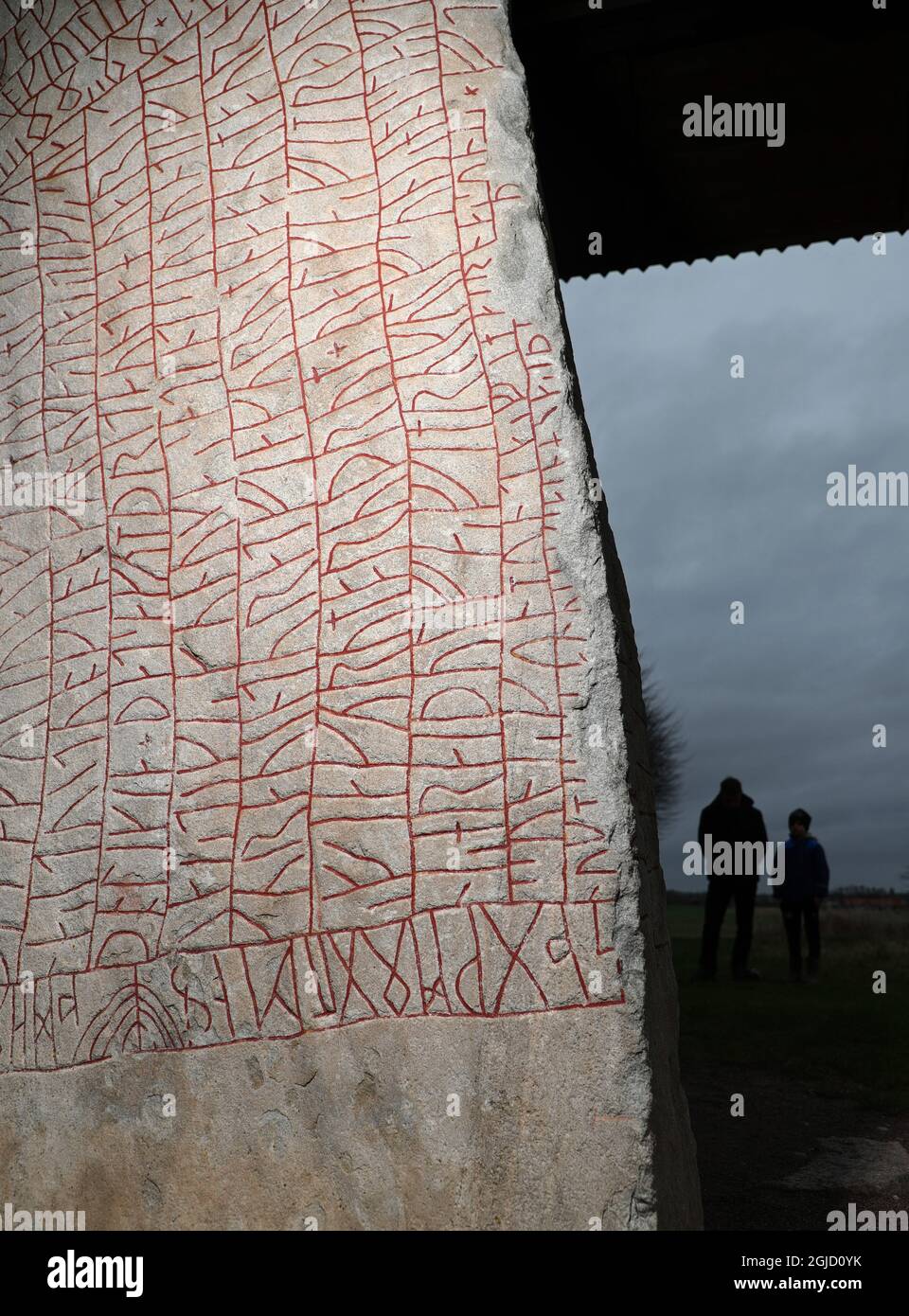 A father and a son look at the Viking-era Rok runestone near the Lake ...