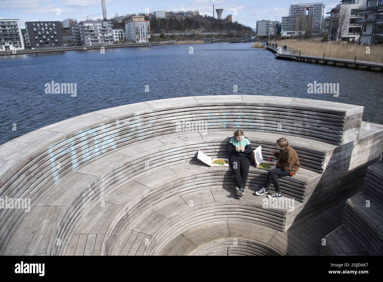Two people sharing a pizza while practicing social distancing from ...