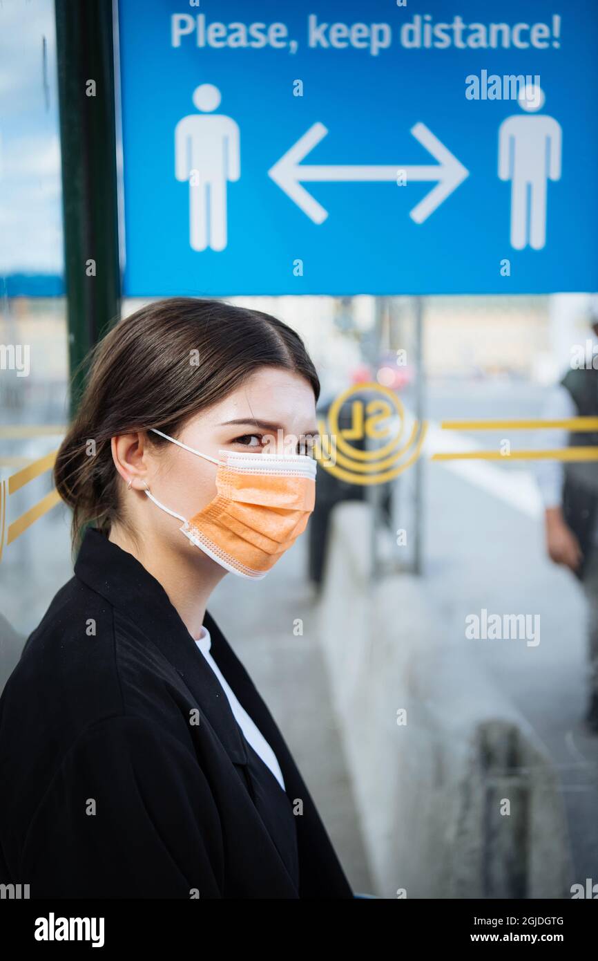 A young woman wearing a face mask, personal protective equipment (PPE ...