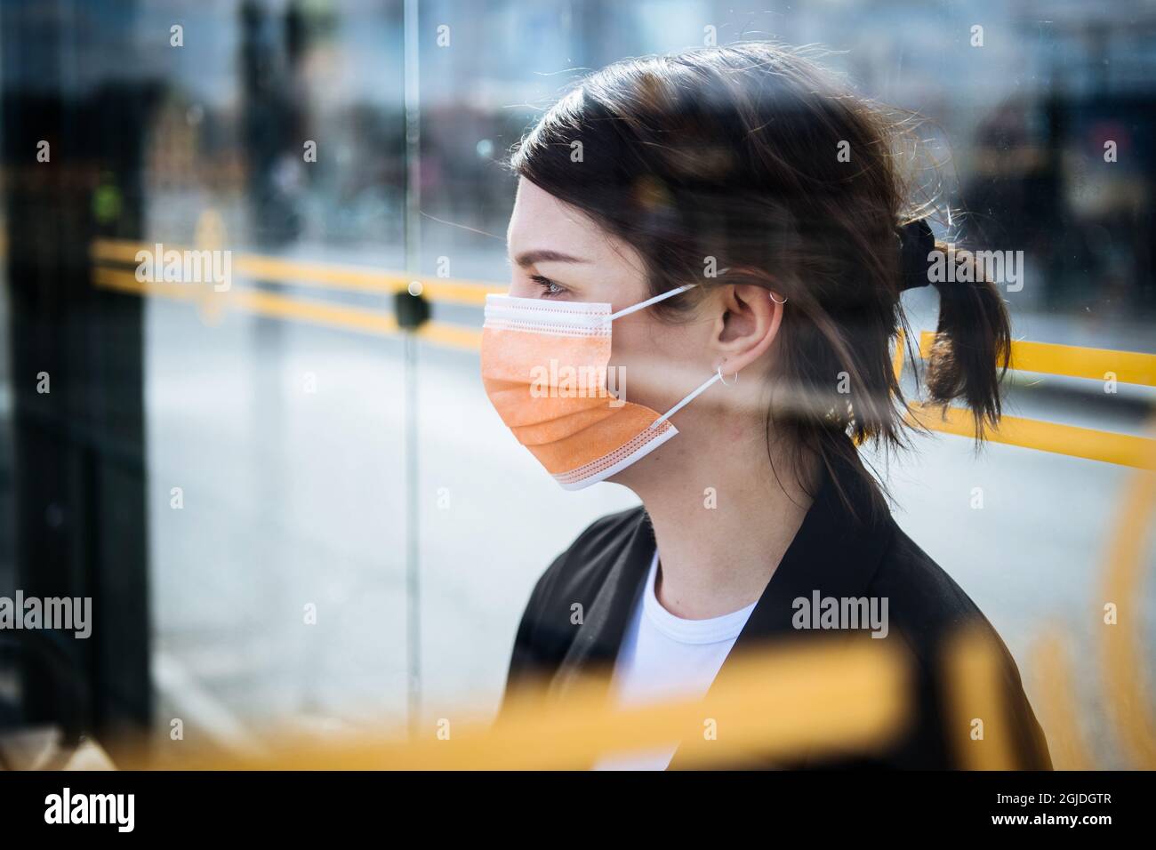 A young woman wearing a face mask, personal protective equipment (PPE ...
