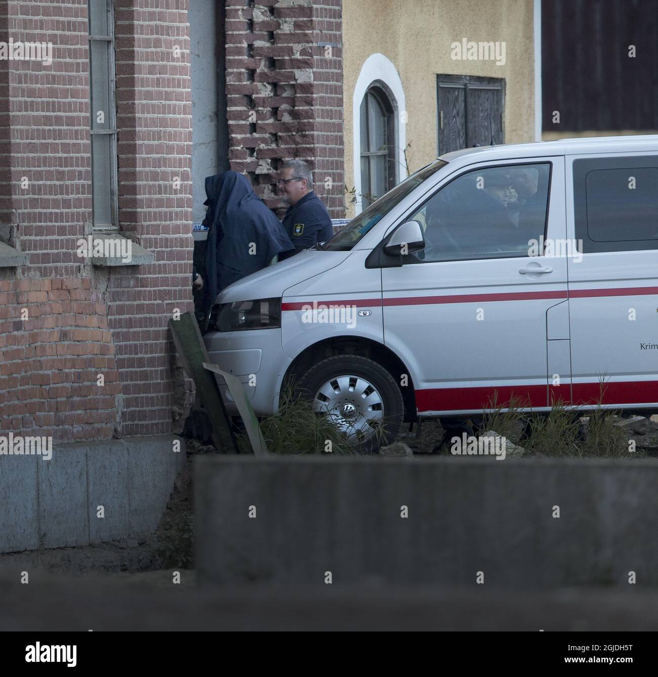 The suspect is led into the barn where the murder allegedly was ...