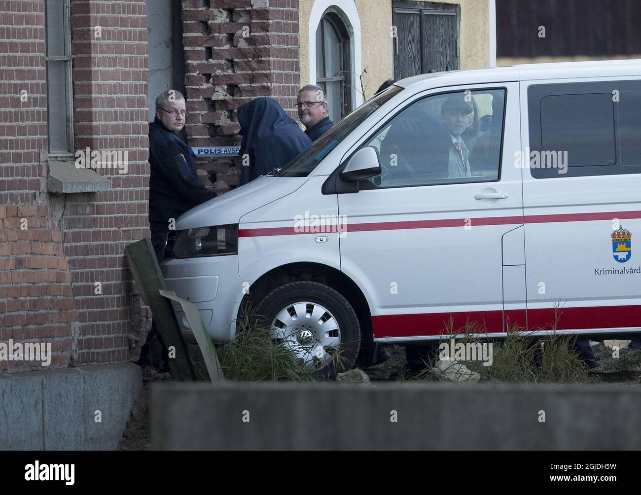 The suspect is led into the barn where the murder allegedly was ...