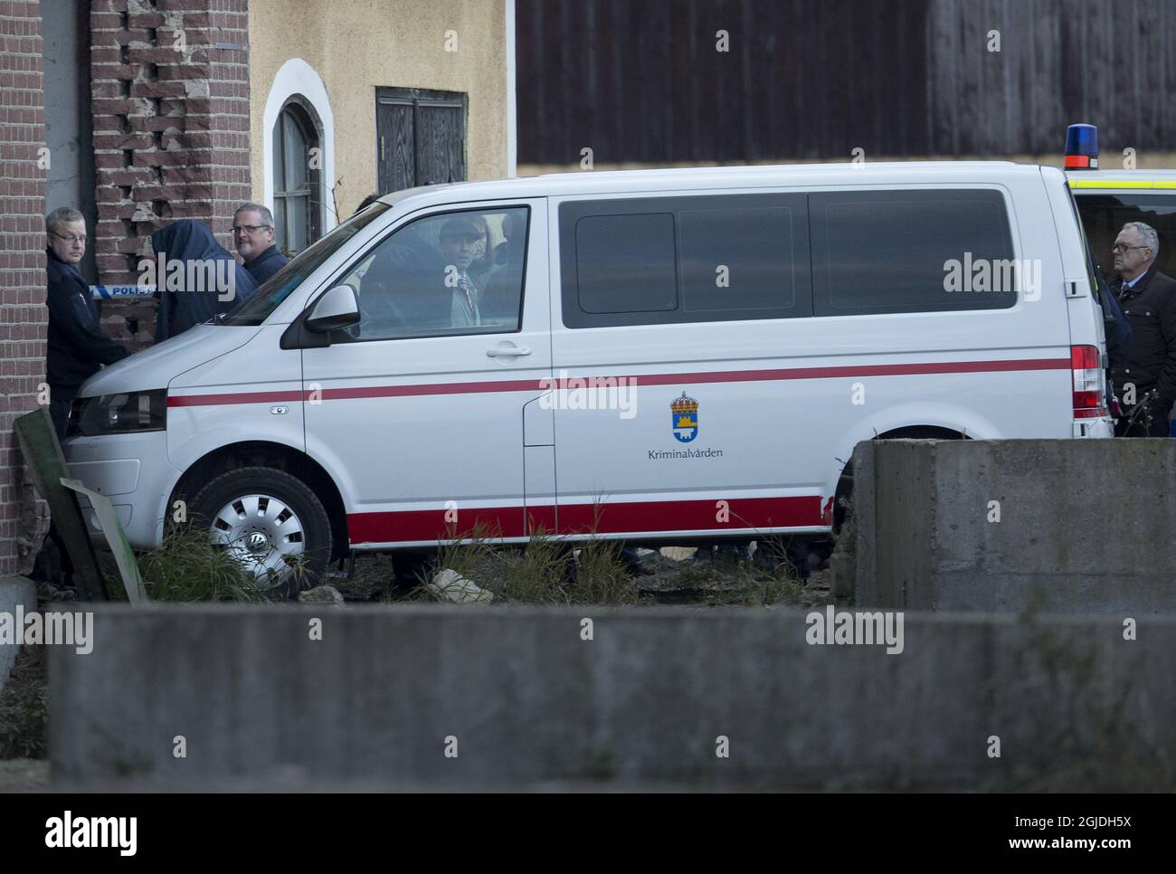 The suspect is led into the barn where the murder allegedly was ...