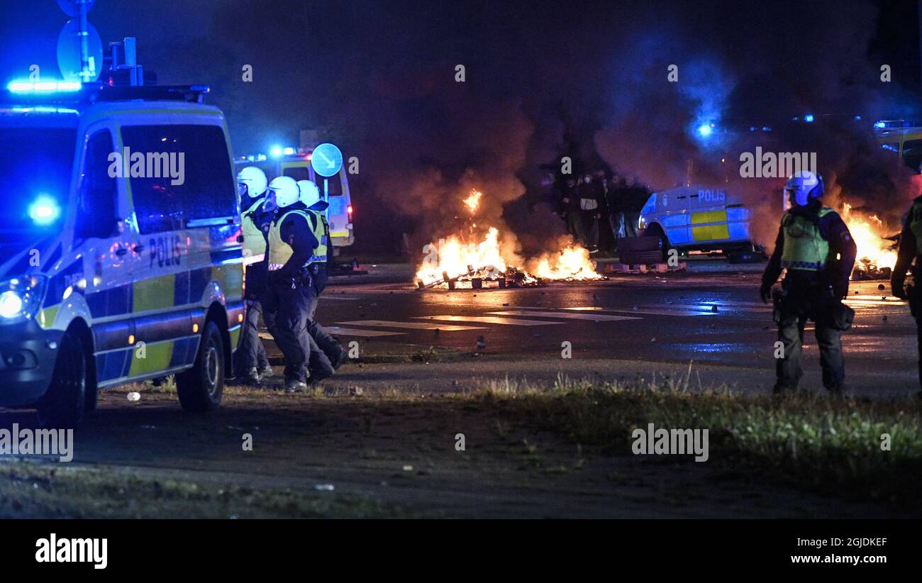 Riot police and smoke billowing from burning tyres and pallets and ...