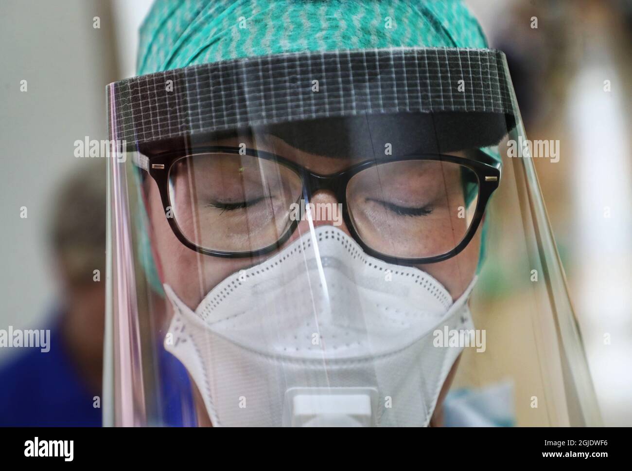 Doctor wearing personal protective equipment (PPE), visor and face mask ...