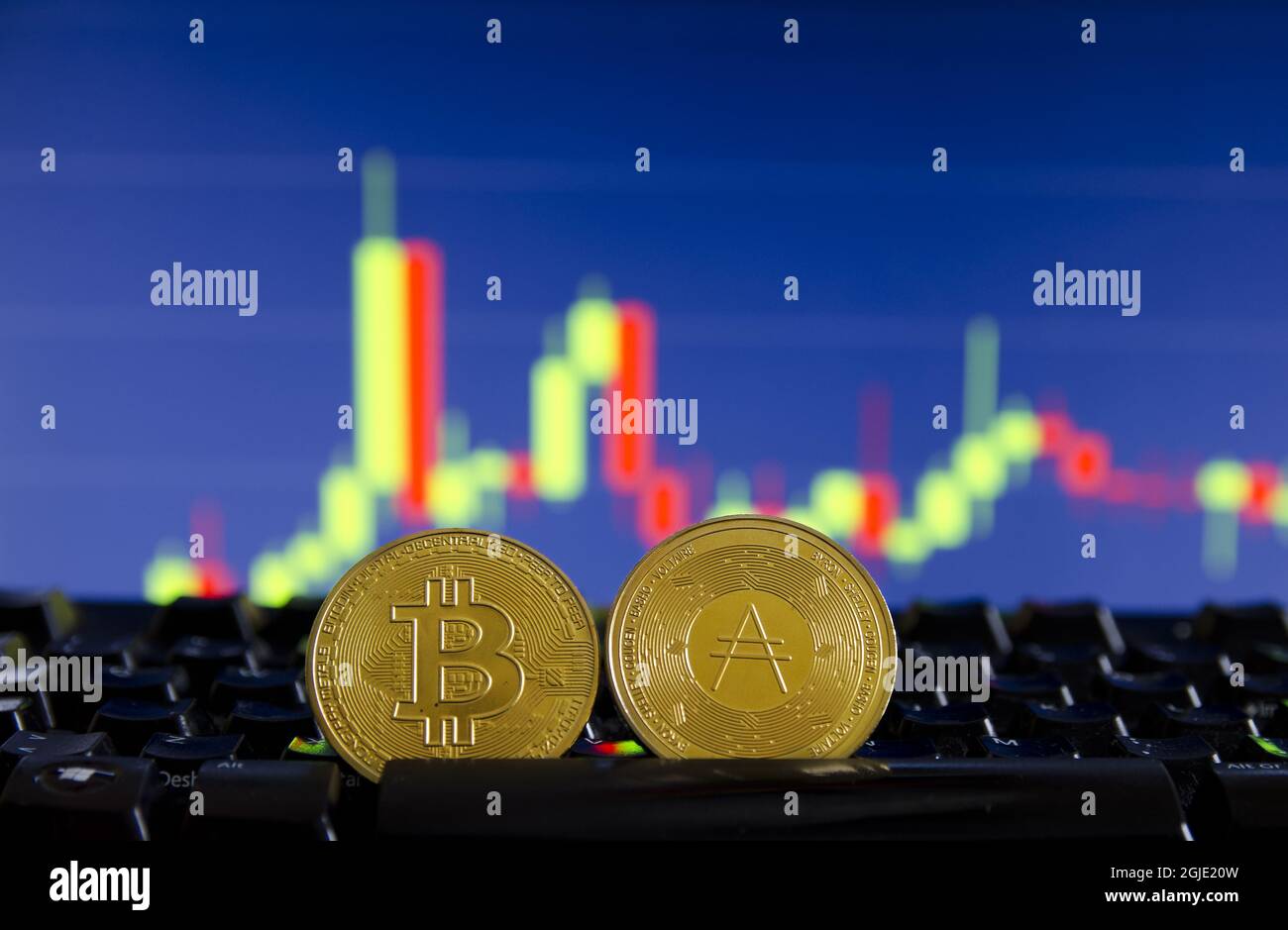 Closeup shot of Bitcoins on the keyboard and graphs on the screen - the ...