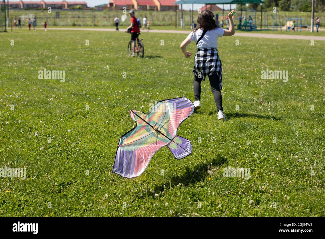 Children fly a kite. Two girls are trying to launch a bird figure ...